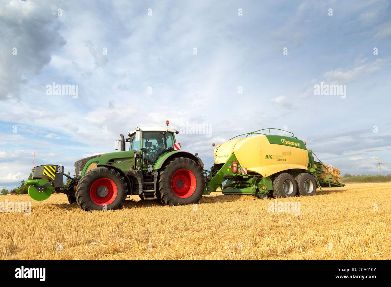 Moving tractor using a hay baler in a field. Much Hadham, Hertfordshire ...