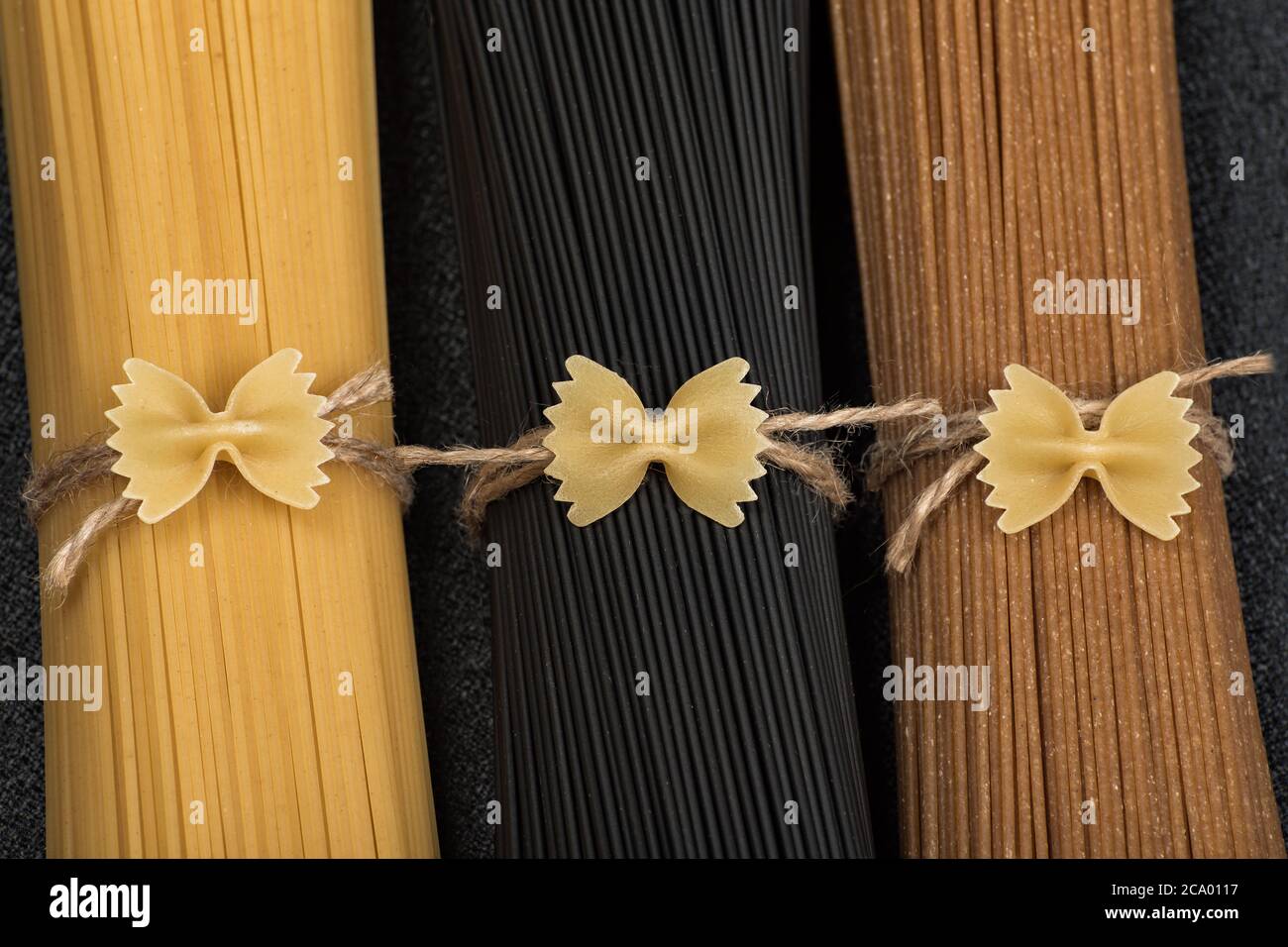 Three bunches of different types of Italian spaghetti. Black, brown and ...
