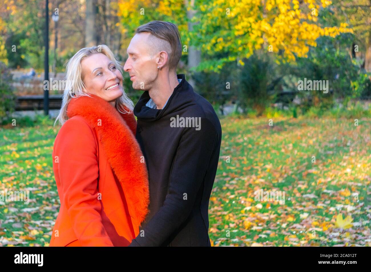Middle-aged couple in autumn park. Smiling pair on colorful fall ...