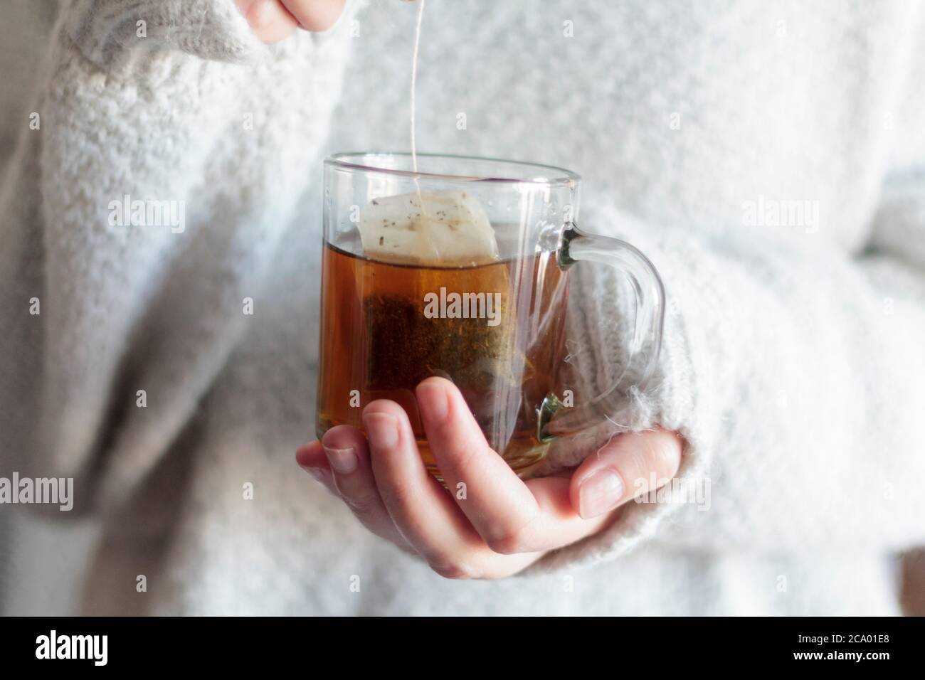 Woman hands dipping tea bag in hot wate Stock Photo - Alamy