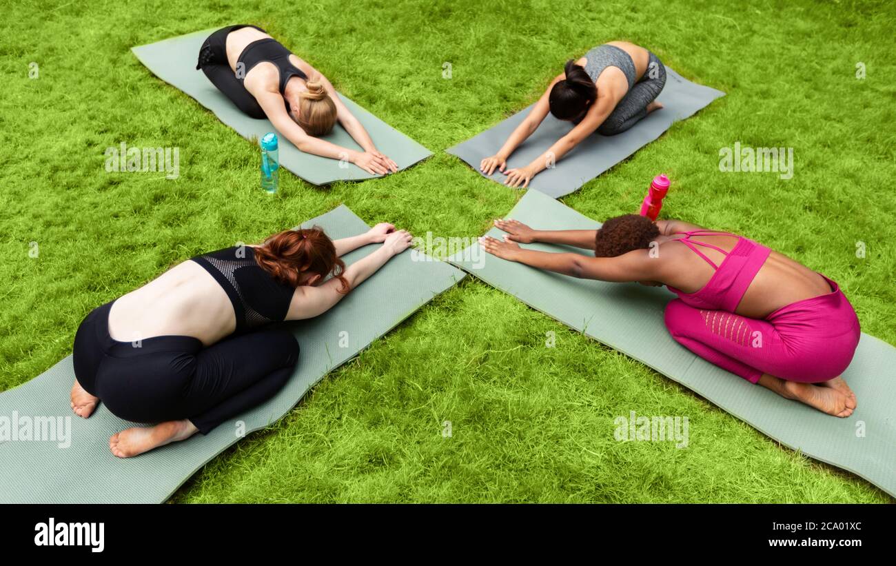 Group of diverse girls performing child pose during their yoga class ...