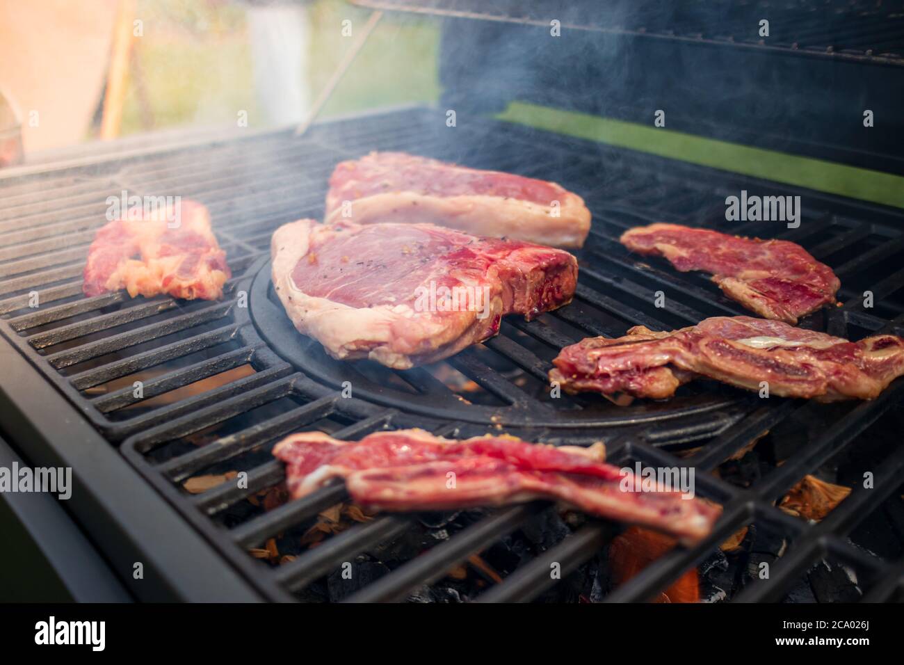 Home barbecue with charcoal in the backyard grilling steaks and other ...