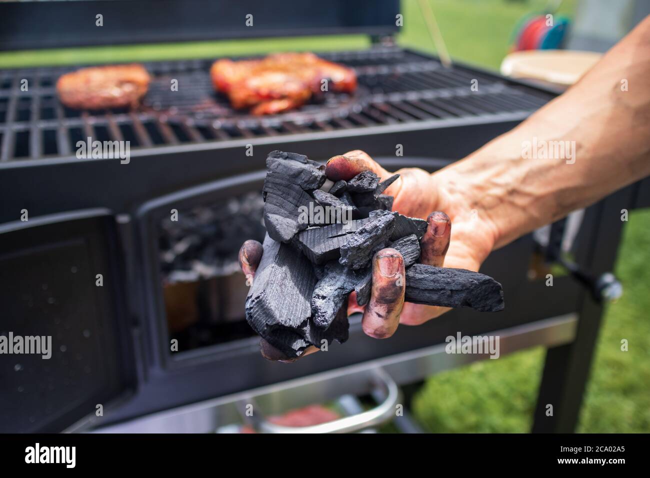 Home barbecue with charcoal in the backyard grilling steaks and other ...