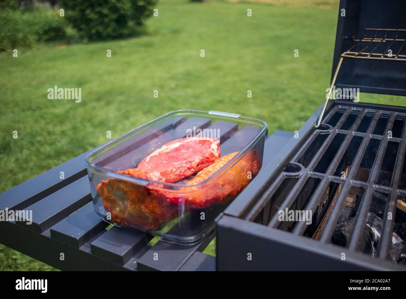 Home barbecue with charcoal in the backyard grilling steaks and other ...