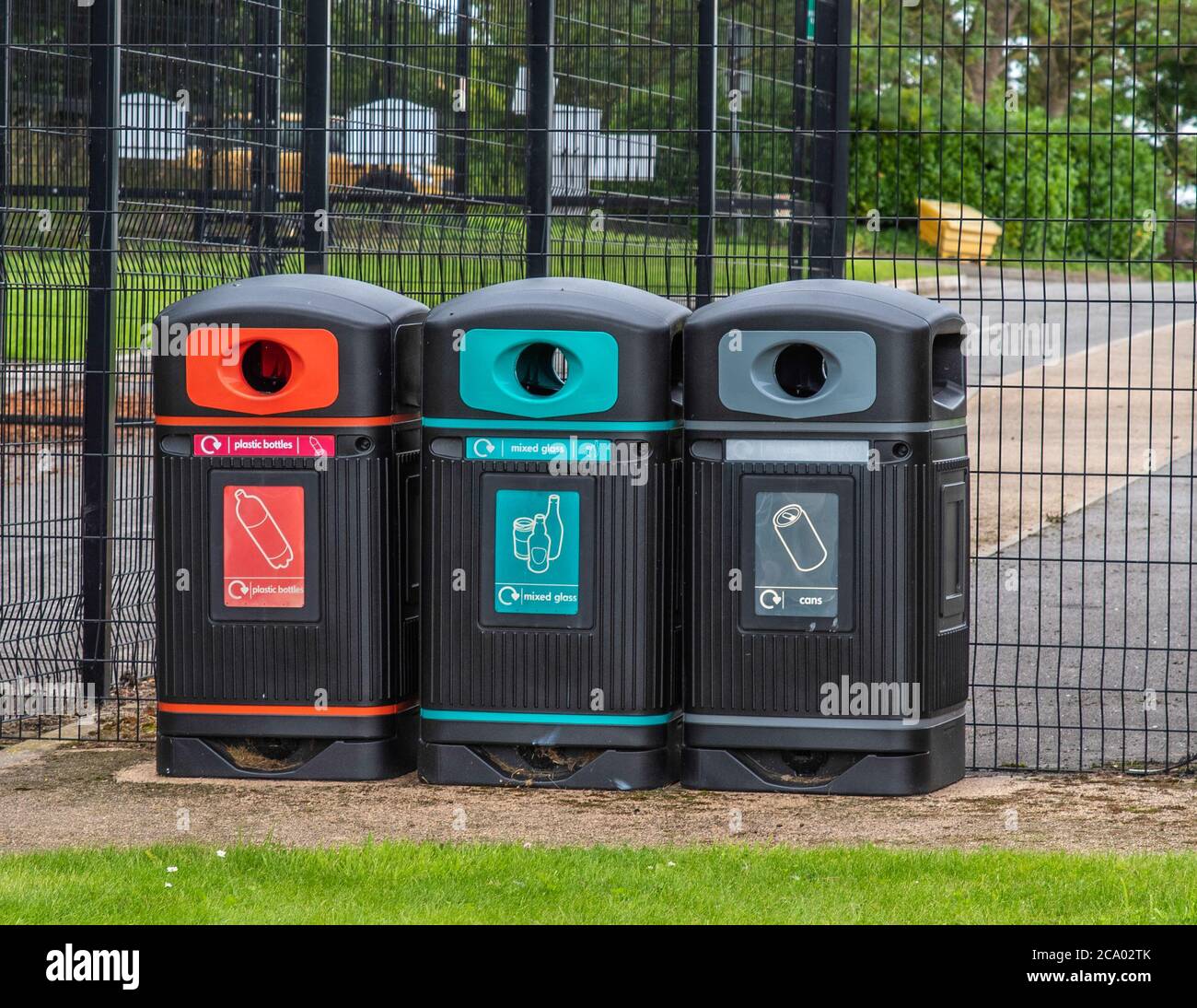 Row of three coloured recycling trash cans, plastic, glass and cans ...