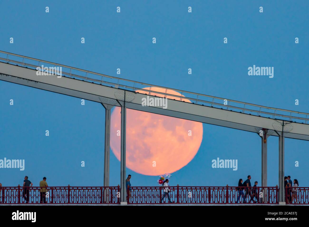 Silhouettes of people on the bridge against the background of the ...