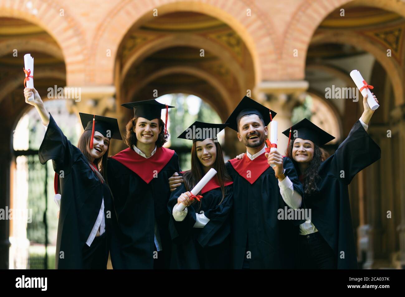 Happy graduation day. 5 graduates hold his graduate diplomas in their ...