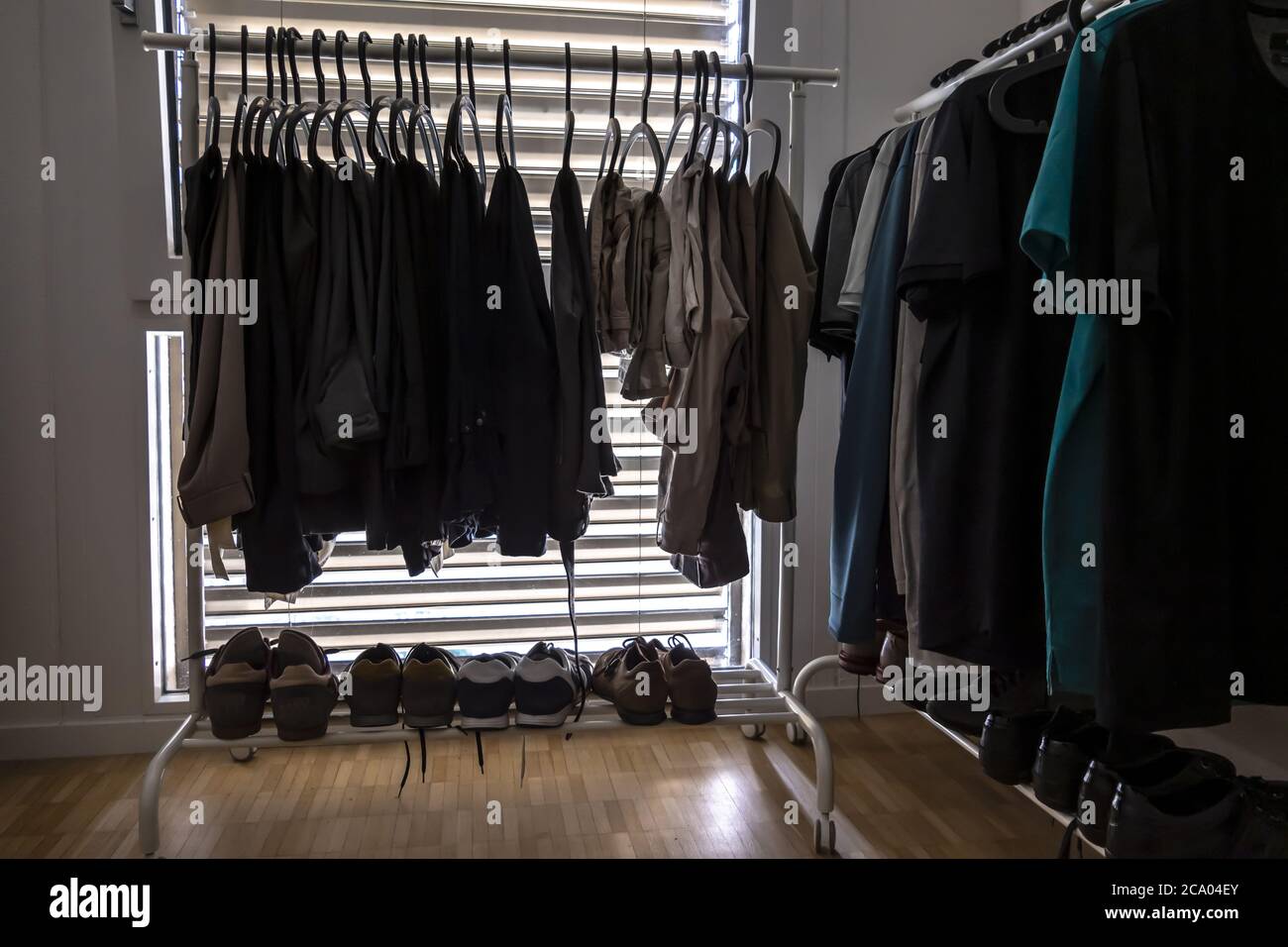 Clothes Hanger on Rack and Shoes Against a Window with Blinds in ...