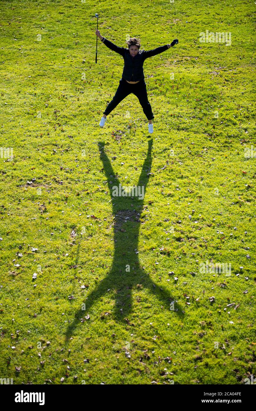 Happy Golfer Holding Golf Club And Jumping with Shadow Stock Photo - Alamy