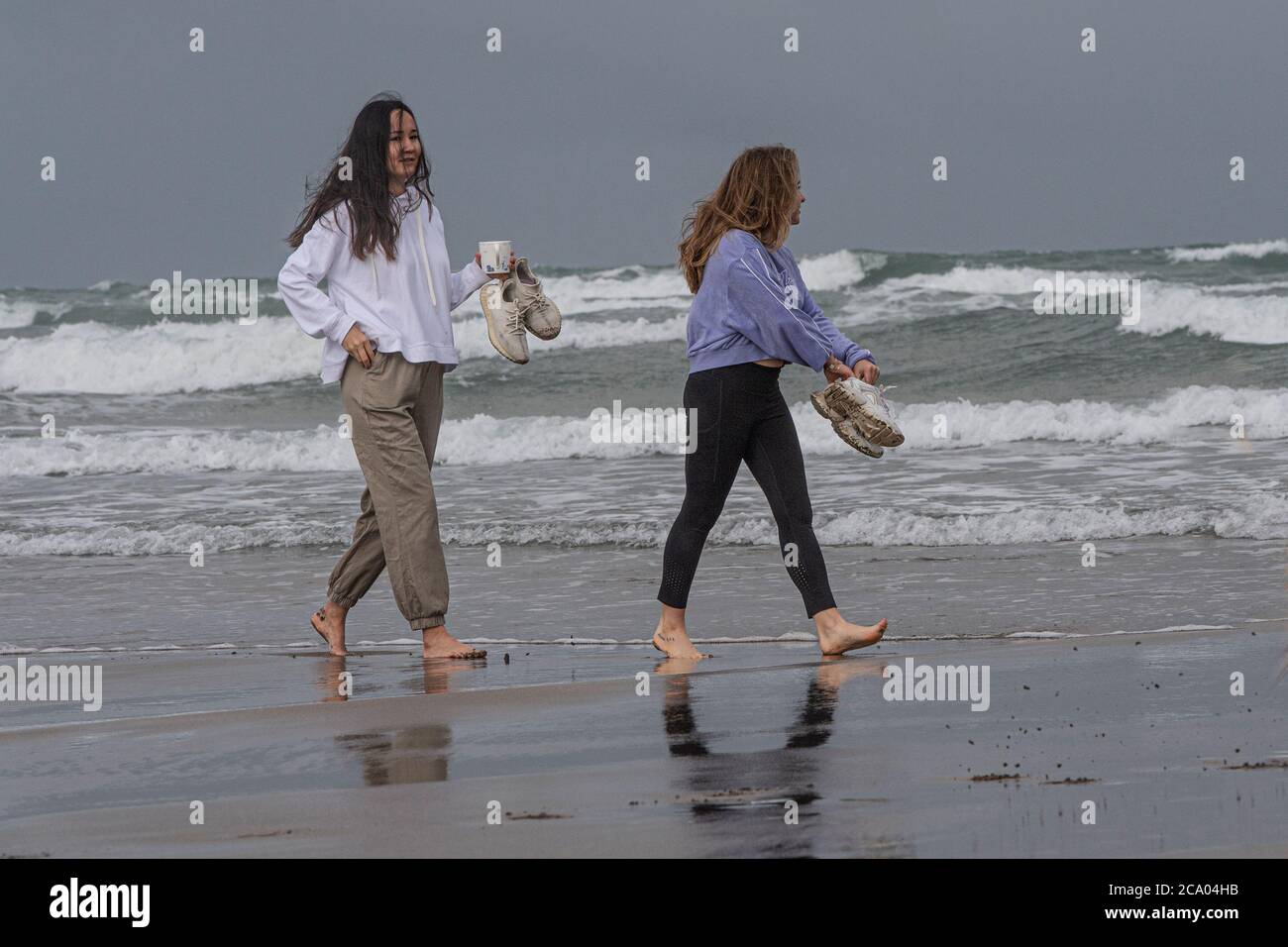 Tourists walking along beach hi-res stock photography and images - Alamy