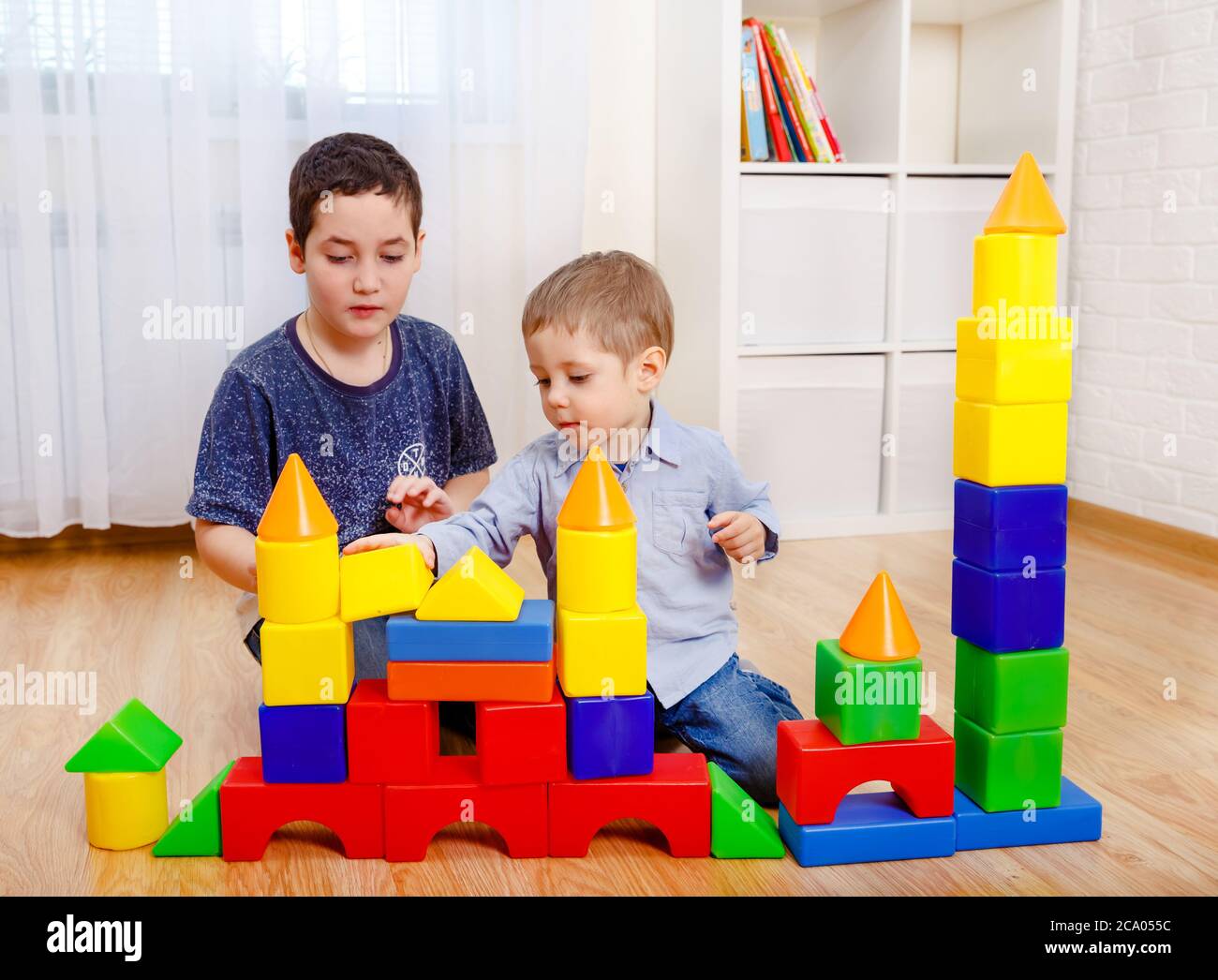 Charming children playing with constructor on floor at home Stock Photo ...