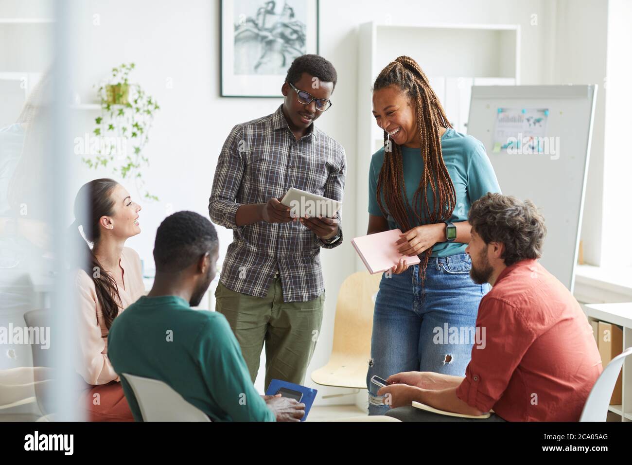 Multi Ethnic Group Of People Sitting In Circle While Discussing