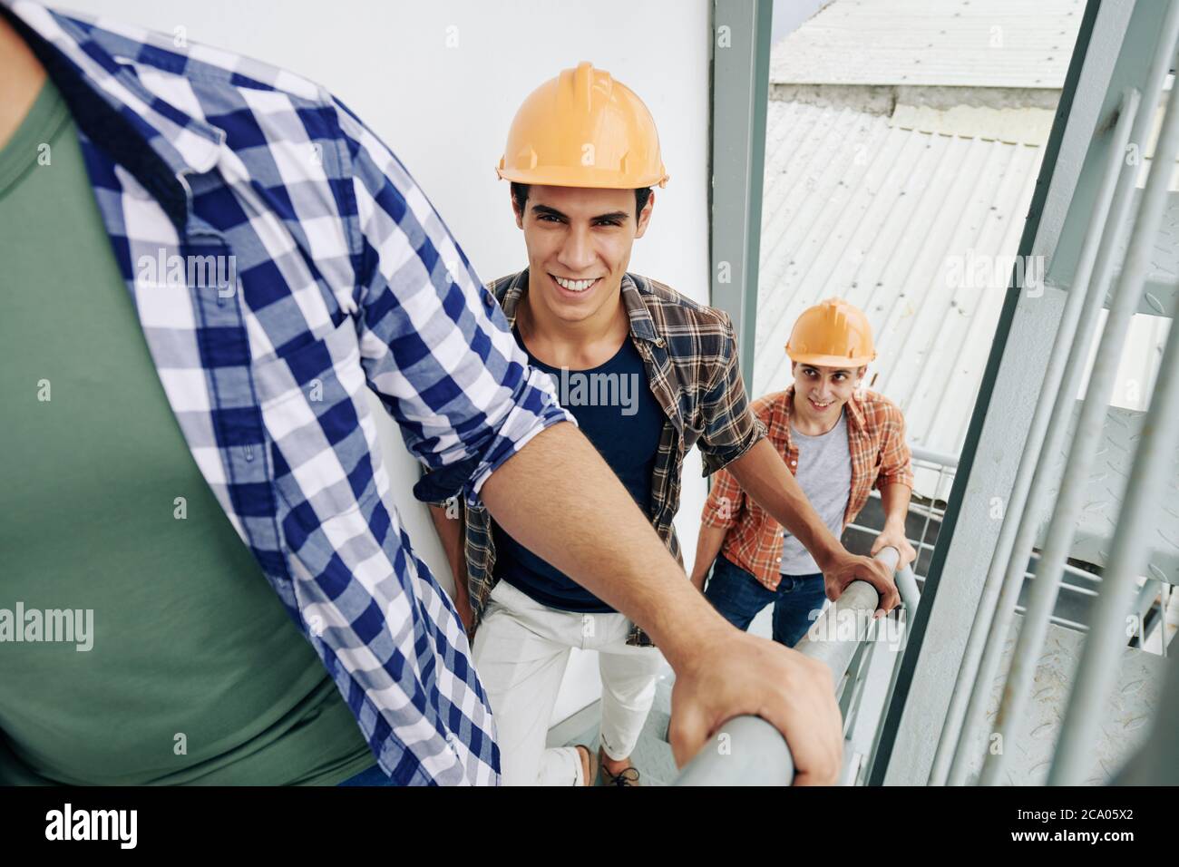 Handsome young construction engineer walking up the stairs when going ...