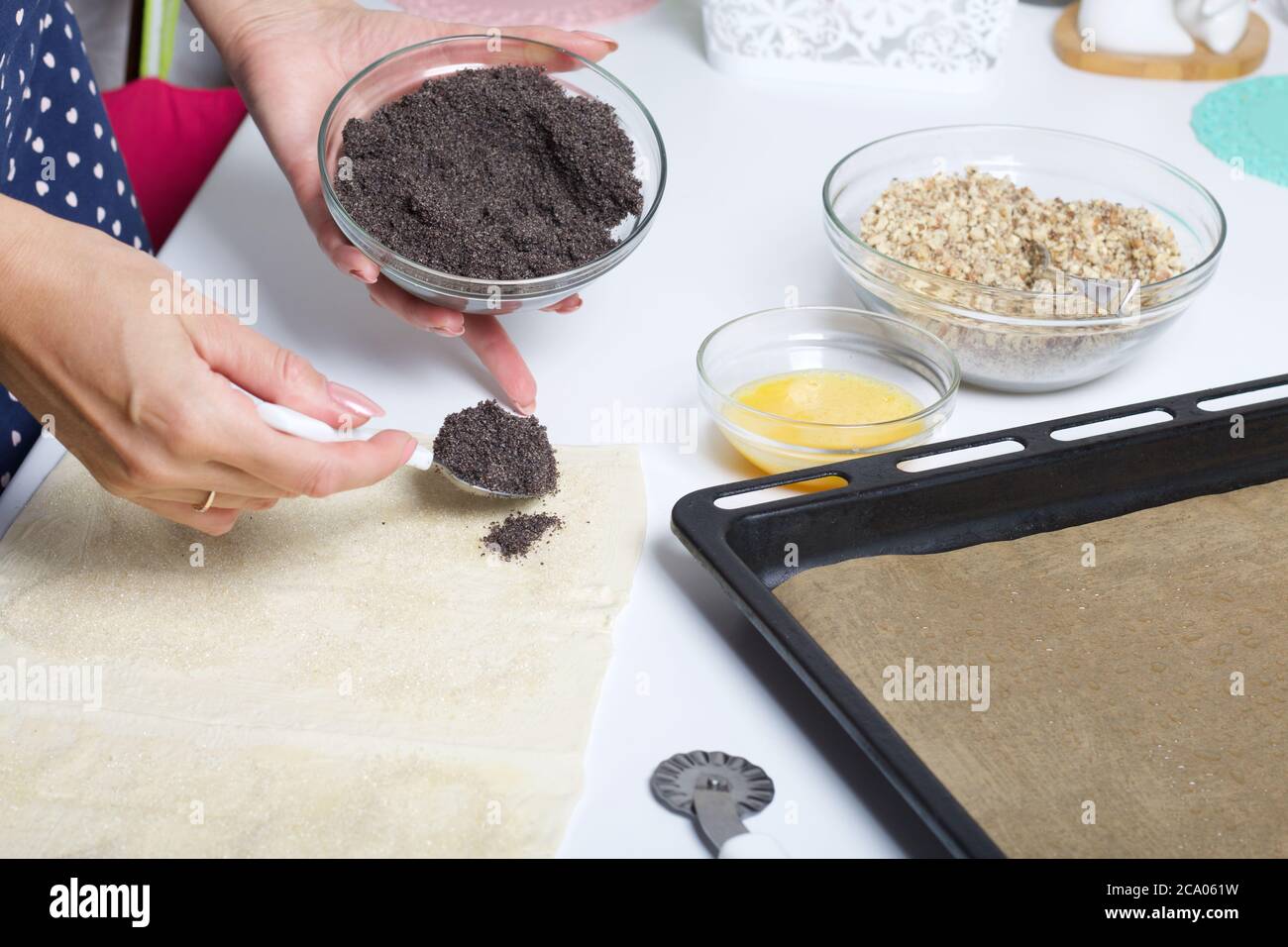 Woman sends poppy seeds puff pastry. For making puff pastry curls with ...