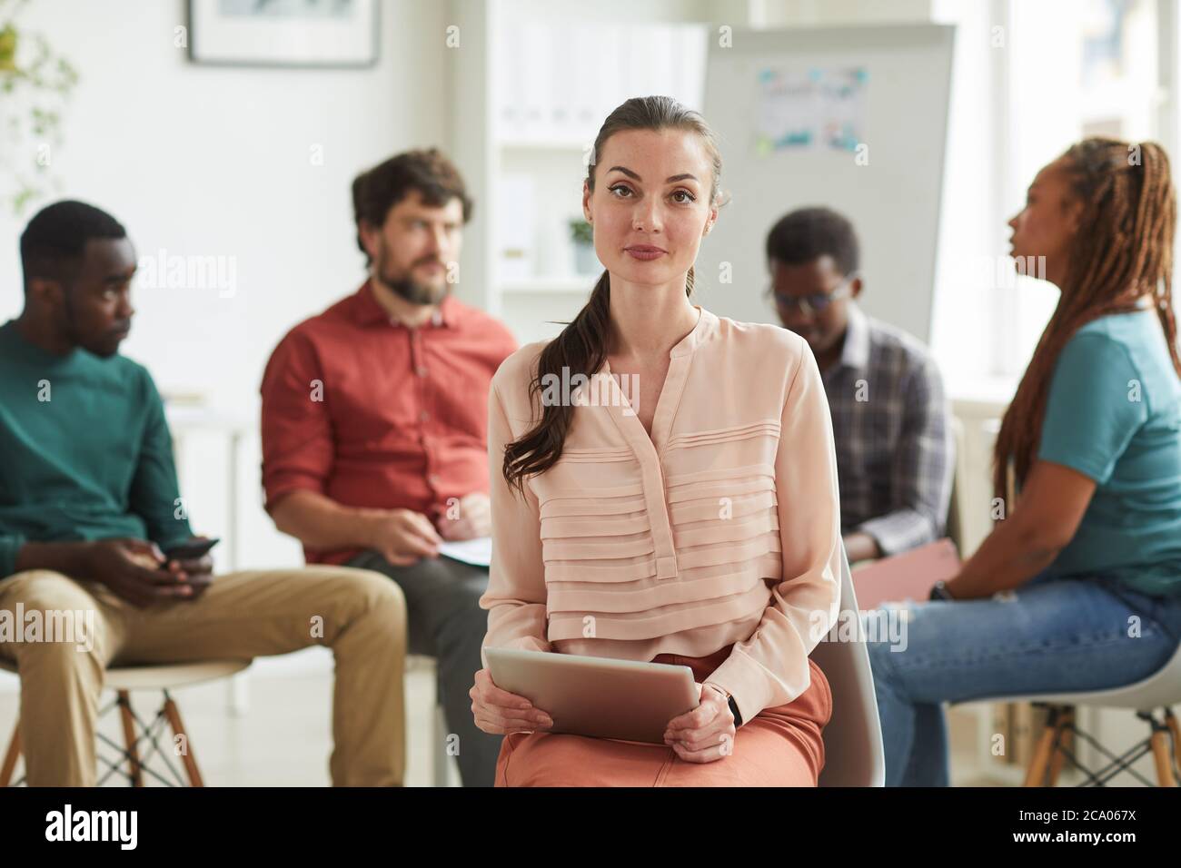 Multi-ethnic group of people sitting in circle while discussing ...