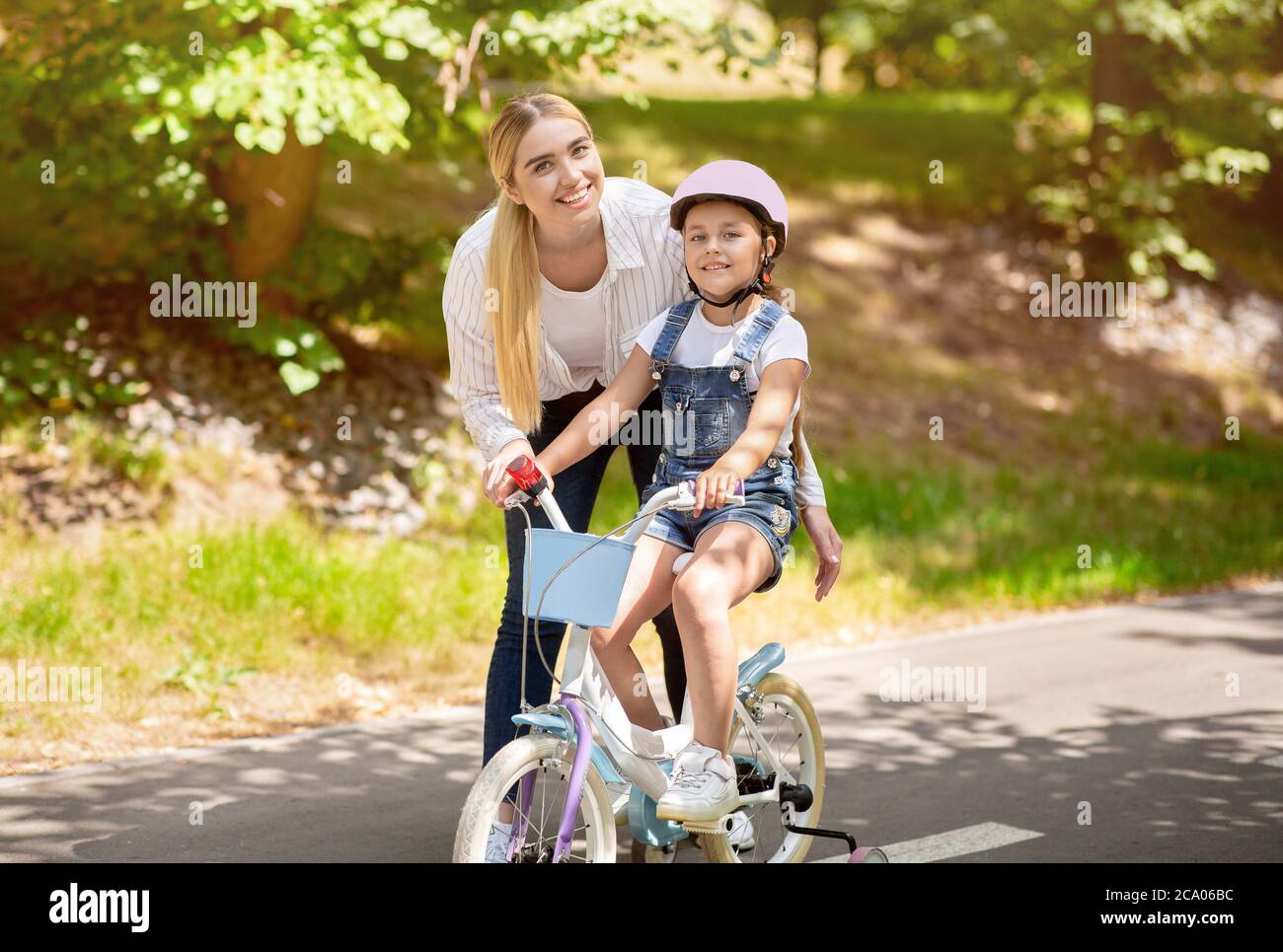 Little Daughter Riding Bike Spending Weekend With Mother In Park Stock ...