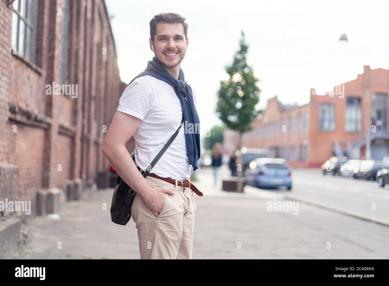 Handsome young man on a walk in town. Cheerful young man enjoying walk ...
