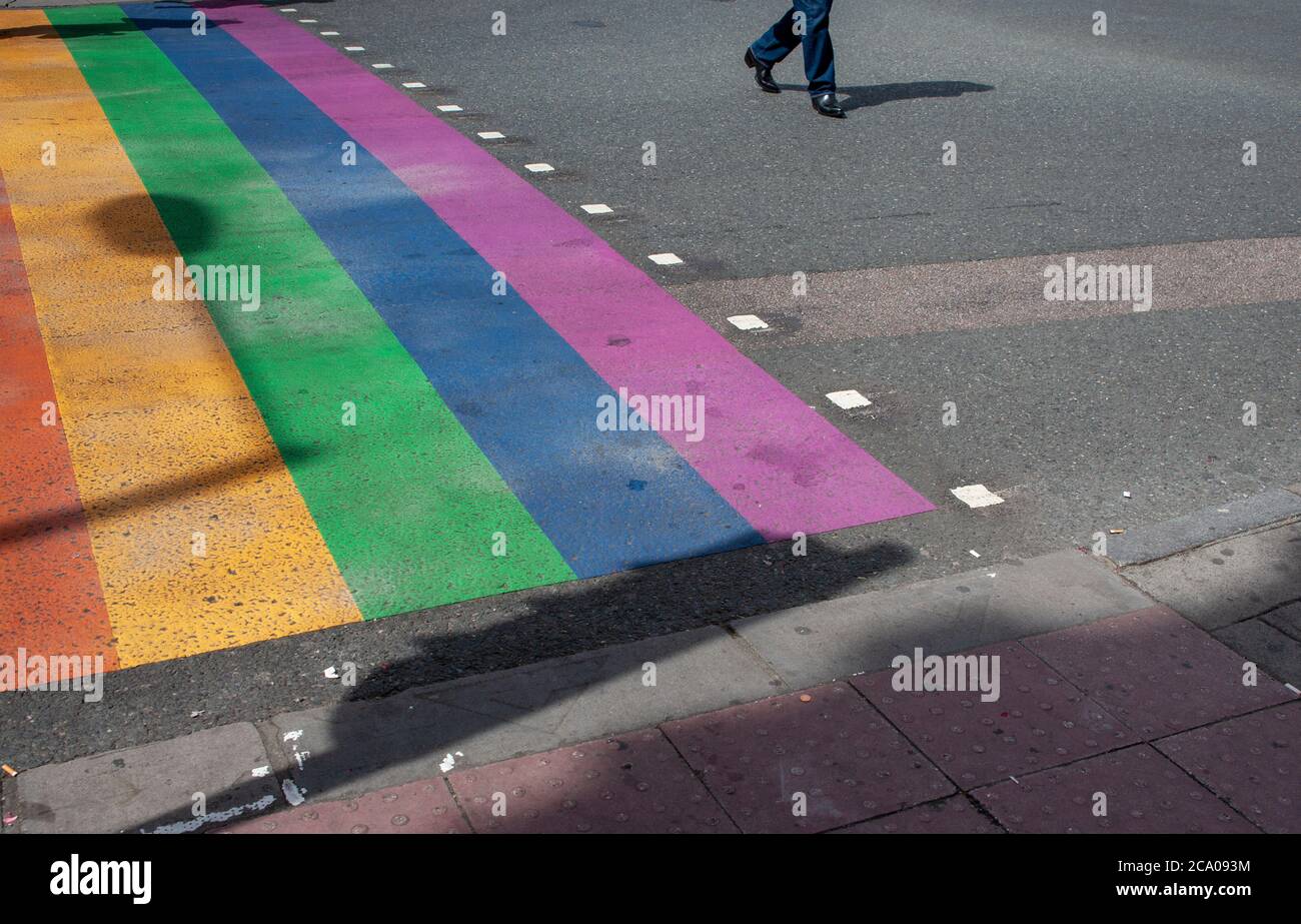 Person walking across a rainbow coloured pedestrian crossing in Camden ...