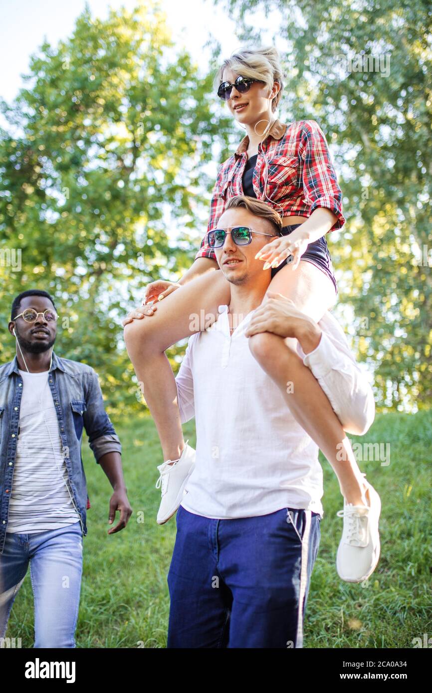 Multi-ethnic group of young cheerful people bonding outdoors, having a ...