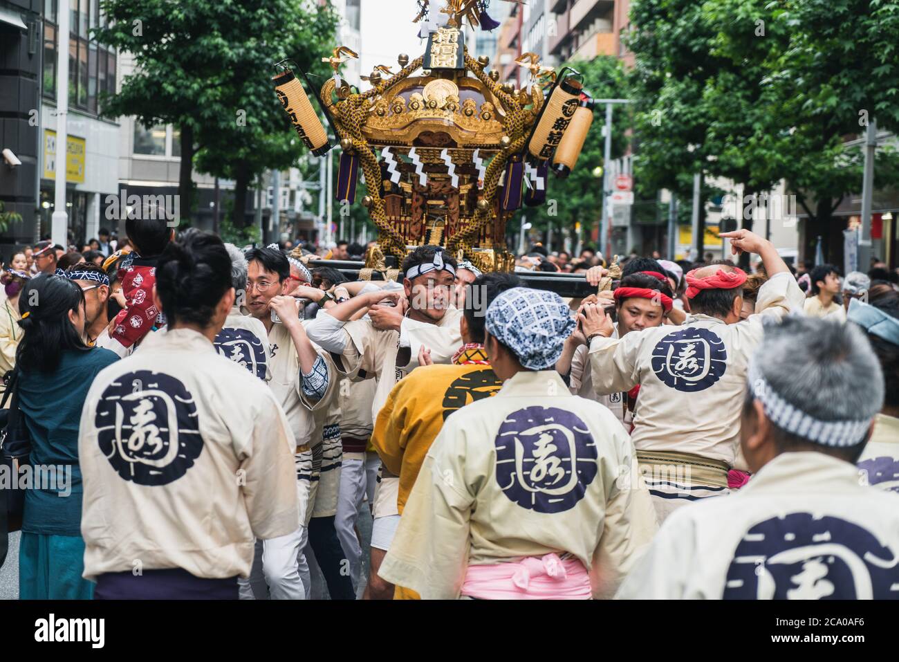 Crowds of japanese people carrying Shinto Shrine Mikoshi around the ...