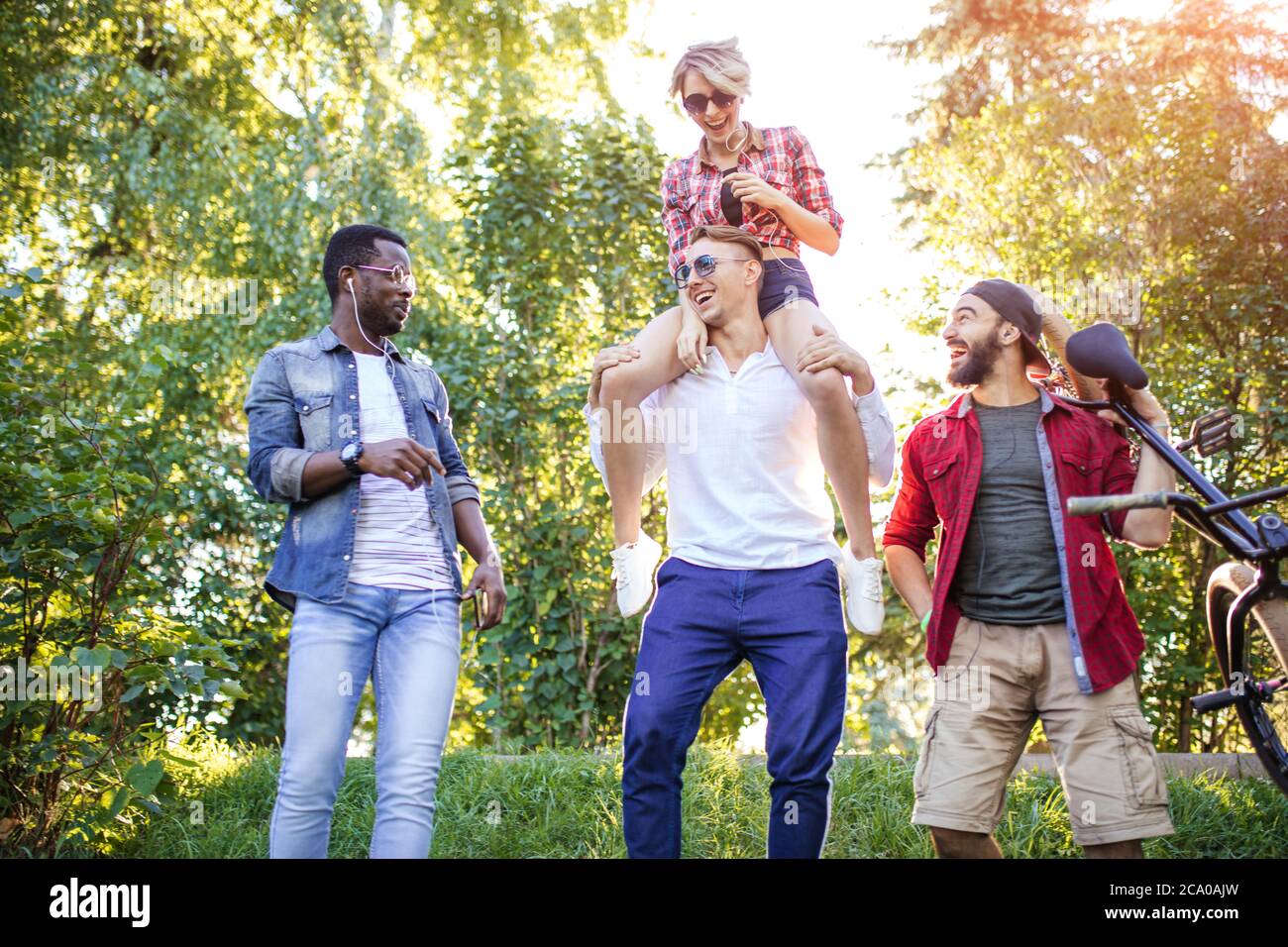 Happy adult guys and girls in casual wear enjoying a long walk ...