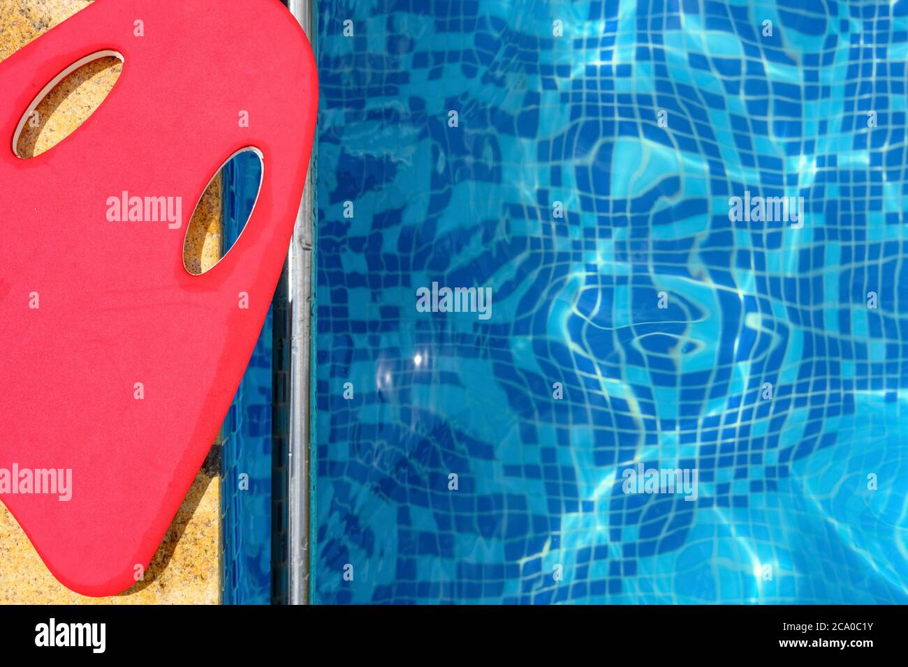 red floating pad near a swimming pool Stock Photo - Alamy