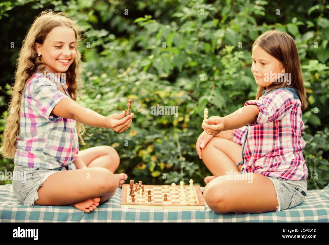 Play chess. Sisters playing chess. Children play chess outdoors nature ...