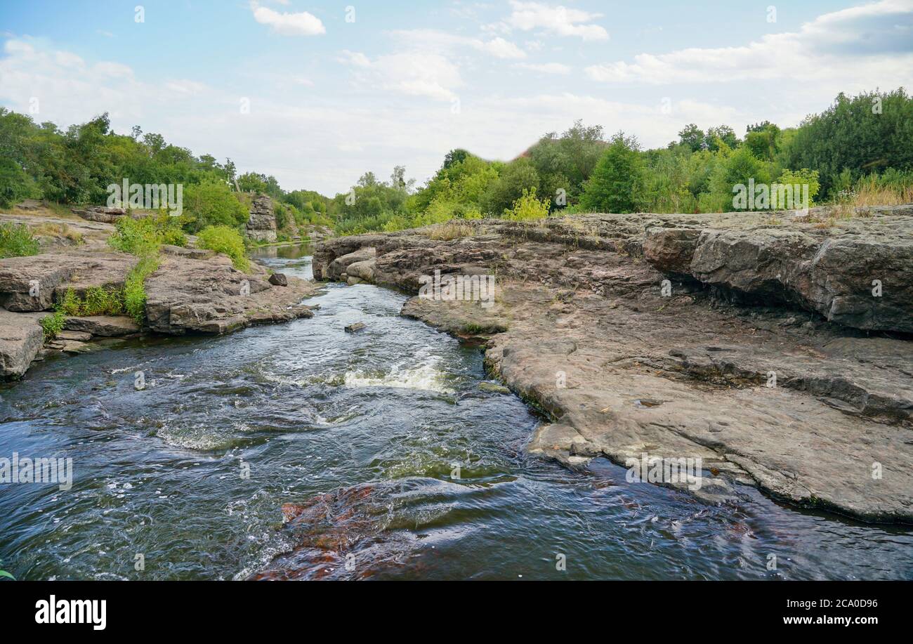 a beautiful mountain stream flows among stones and rocks Stock Photo ...