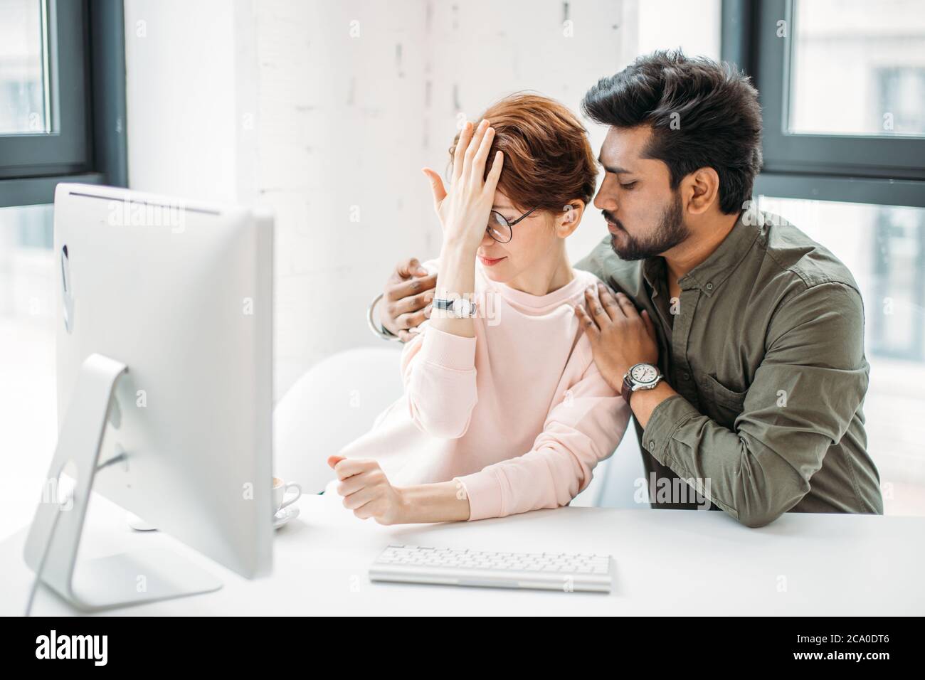 worried business man and woman colleagues looking at computer trying to ...