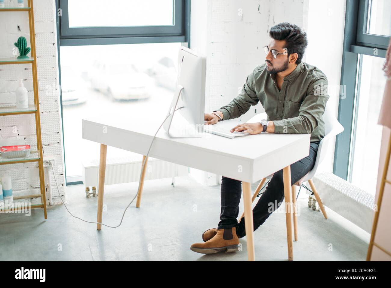 young indian man working at computer from modern bright office Stock ...