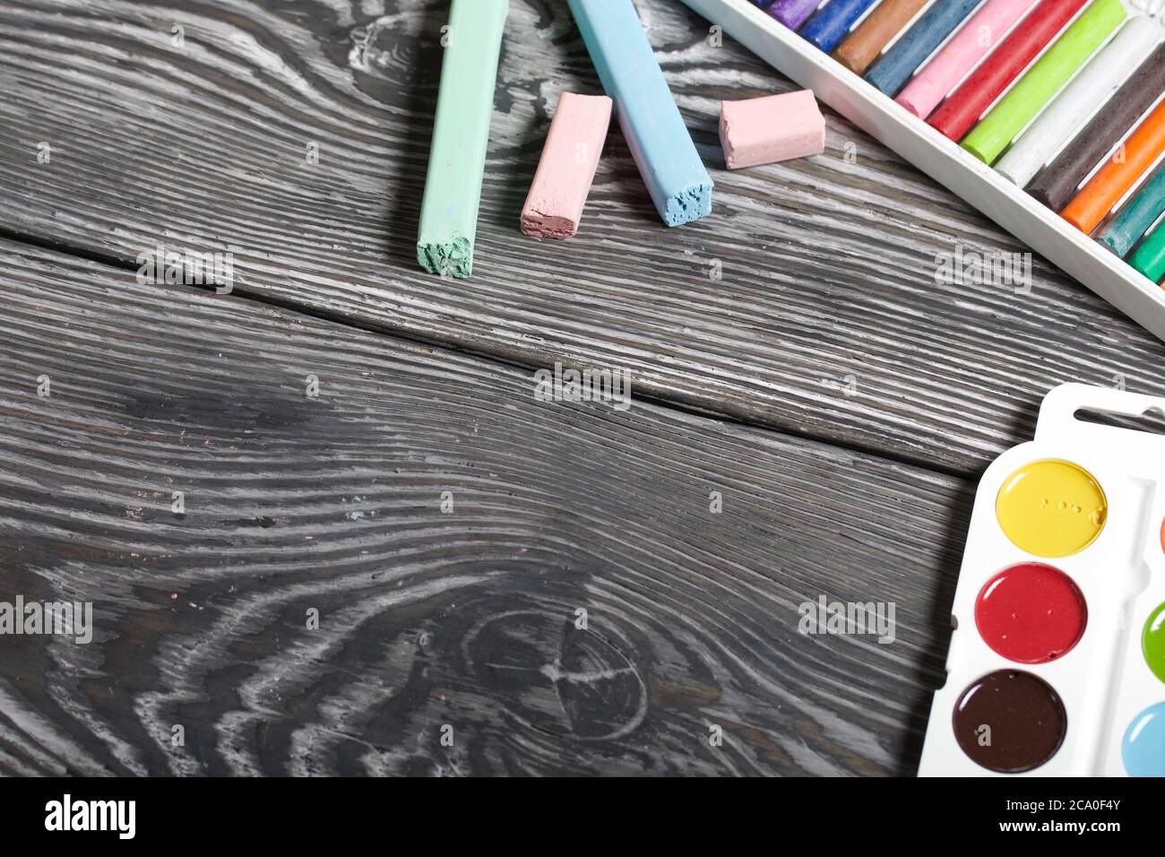 Chalk of different colors, watercolors and pastels for drawing. On ...