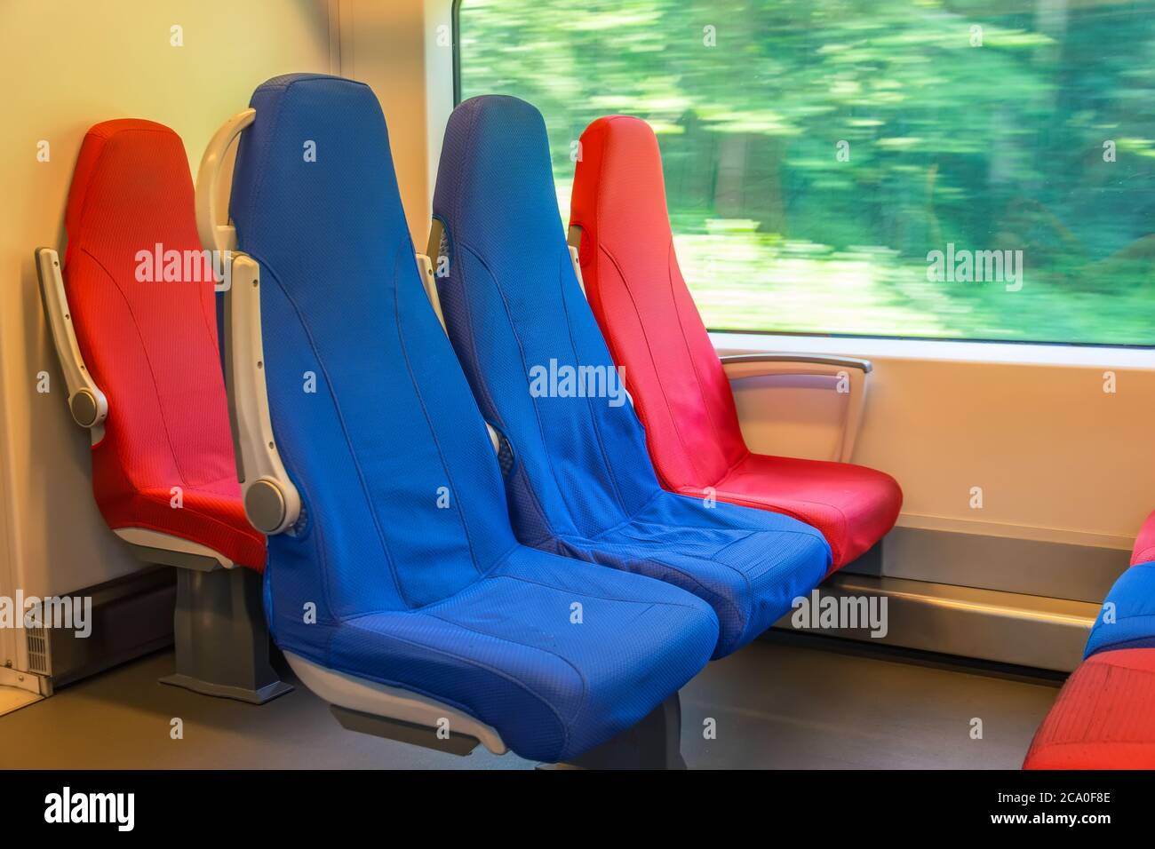 Passenger seats in red and blue colors inside the high-speed train ...