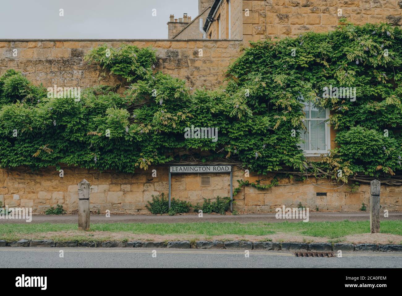 Leamington Road street name sign against the limestone cottage and ...