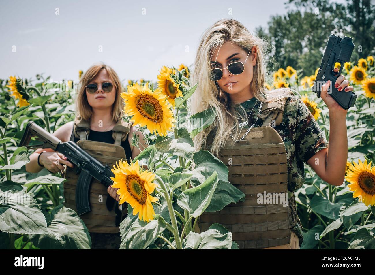 Military team of attractive female soldiers with guns and rifle machine ...