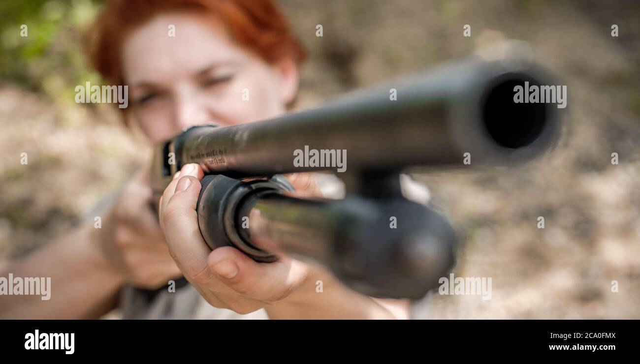 Woman shooting with pump gun. Direct macro detail close-up shotgun ...
