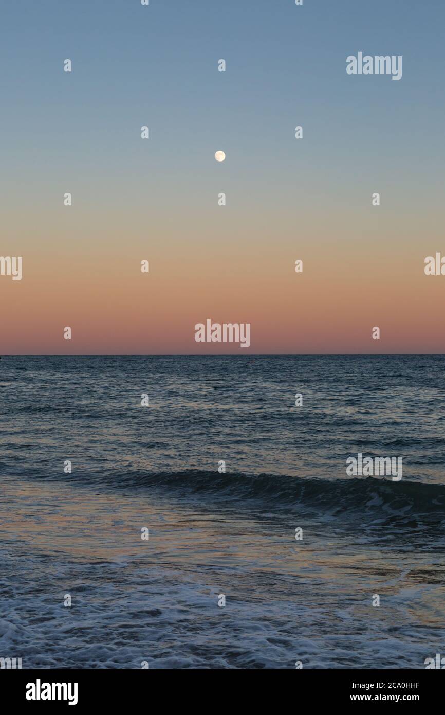 A full moon visible at sunset, over the sea at Brighton Stock Photo - Alamy
