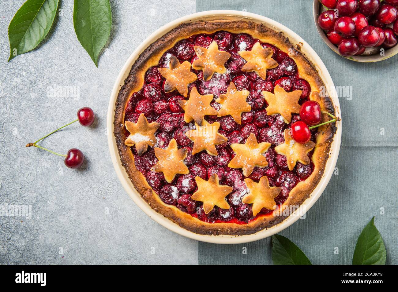 Homemade open cherry pie with frech cherries on a gray concrete ...