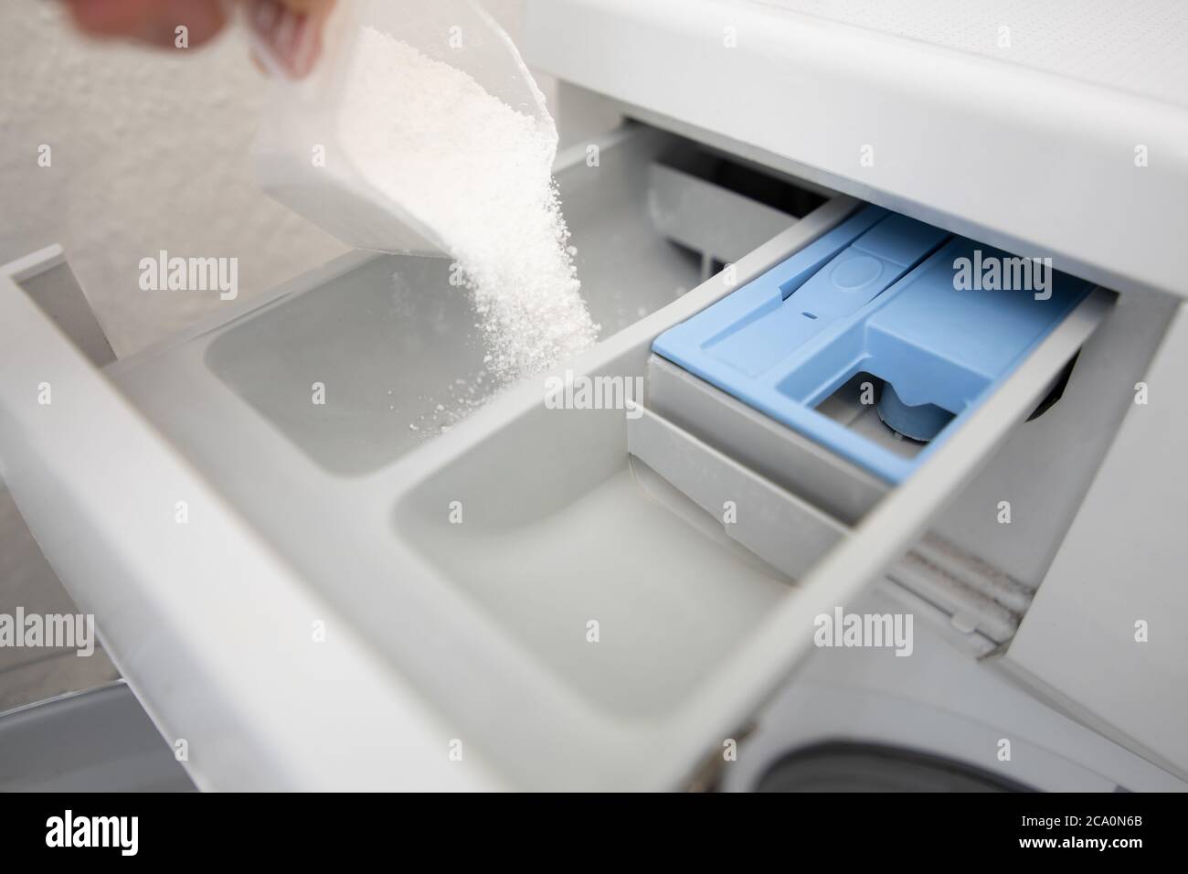 filling the laundry compartment of the washing machine with white ...