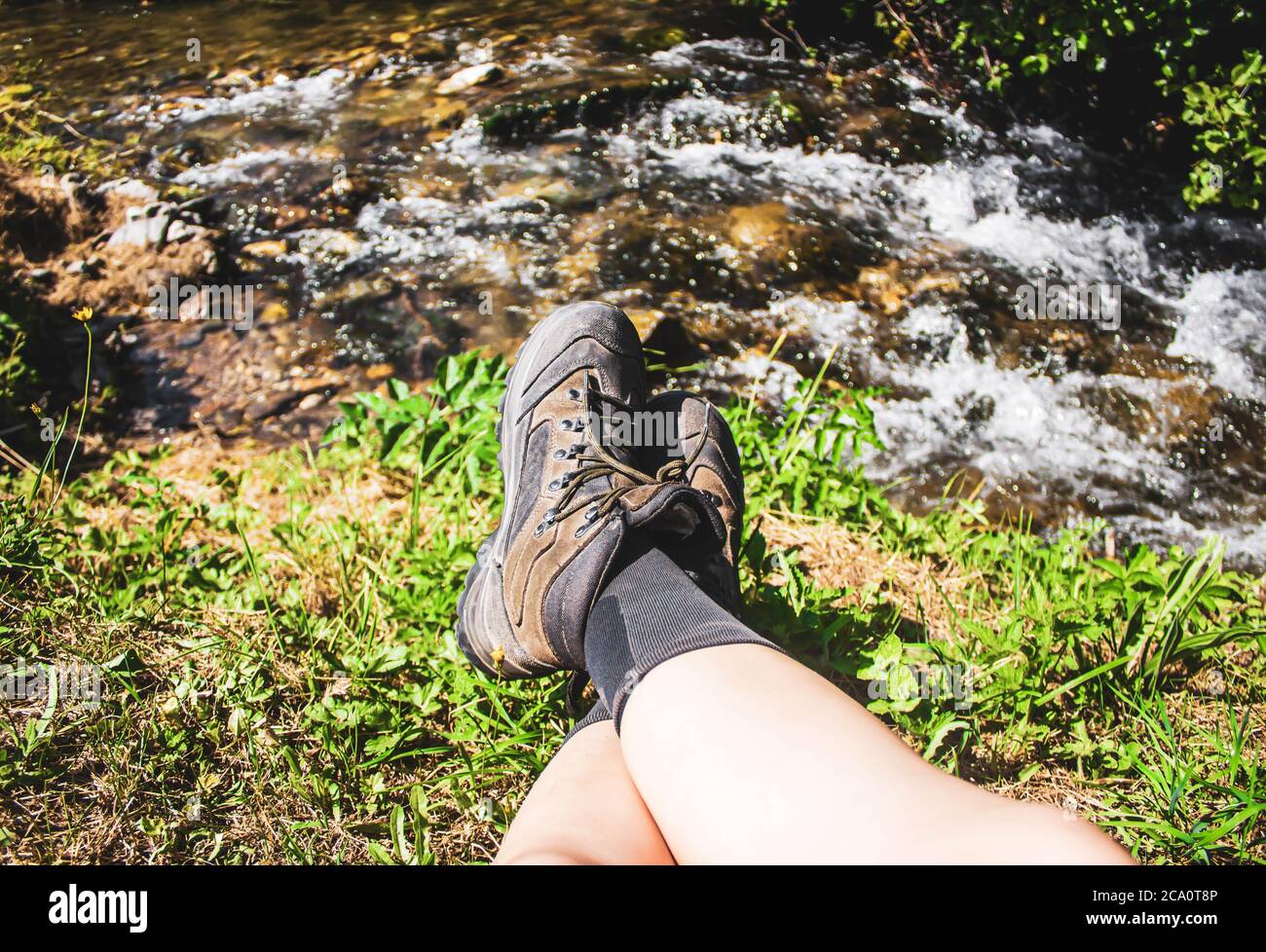 legs in boots on the bank of a river Stock Photo - Alamy