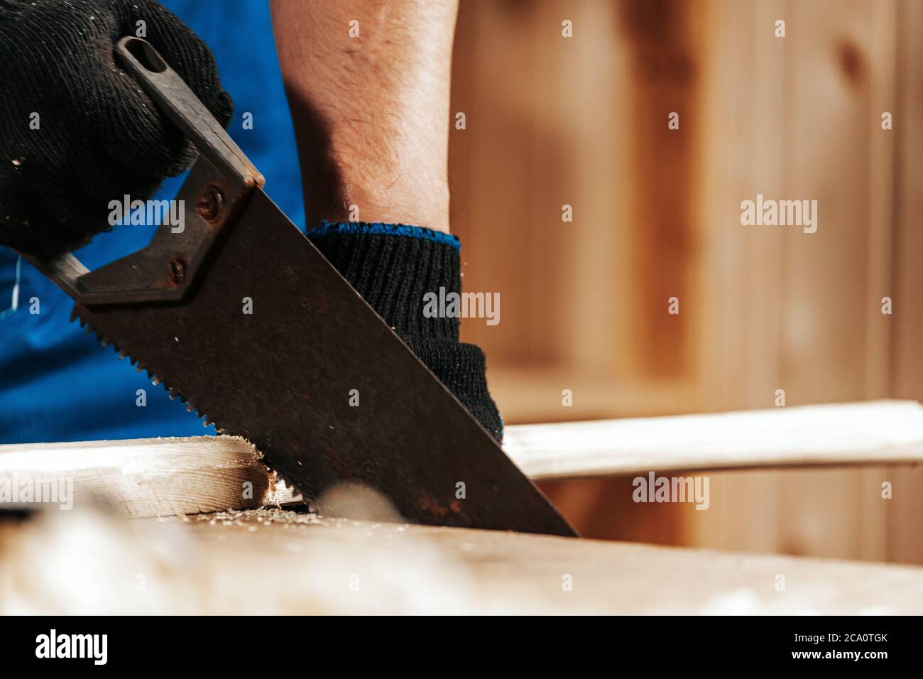 Close up of the man construction worker carpenter sawing a wodden with ...