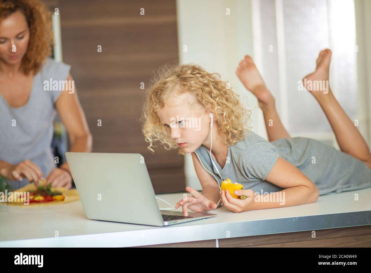 Everyday life in family with kids. Frizzy haired girl watching cartoons ...