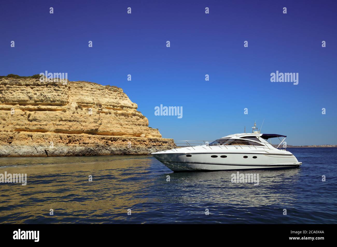Boat at cliff in the ocean at coast Stock Photo - Alamy