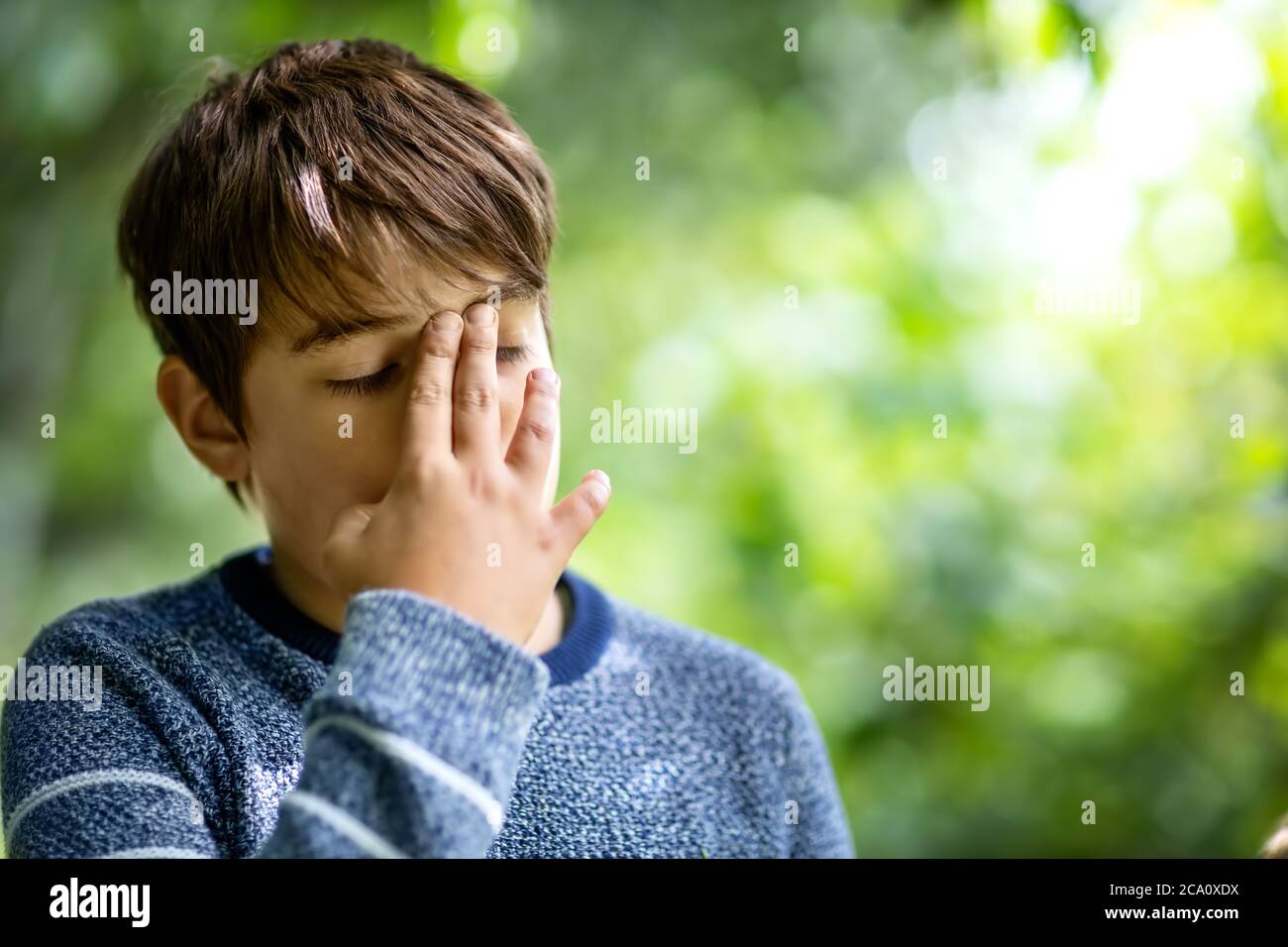 child with headache. Upset young boy outdoors Stock Photo - Alamy