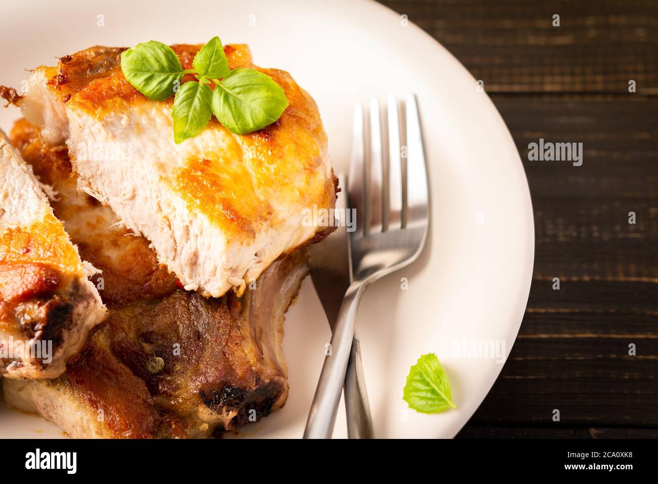 Fried pork entrecote on the bone, cooked pieces of pork meat with basil ...