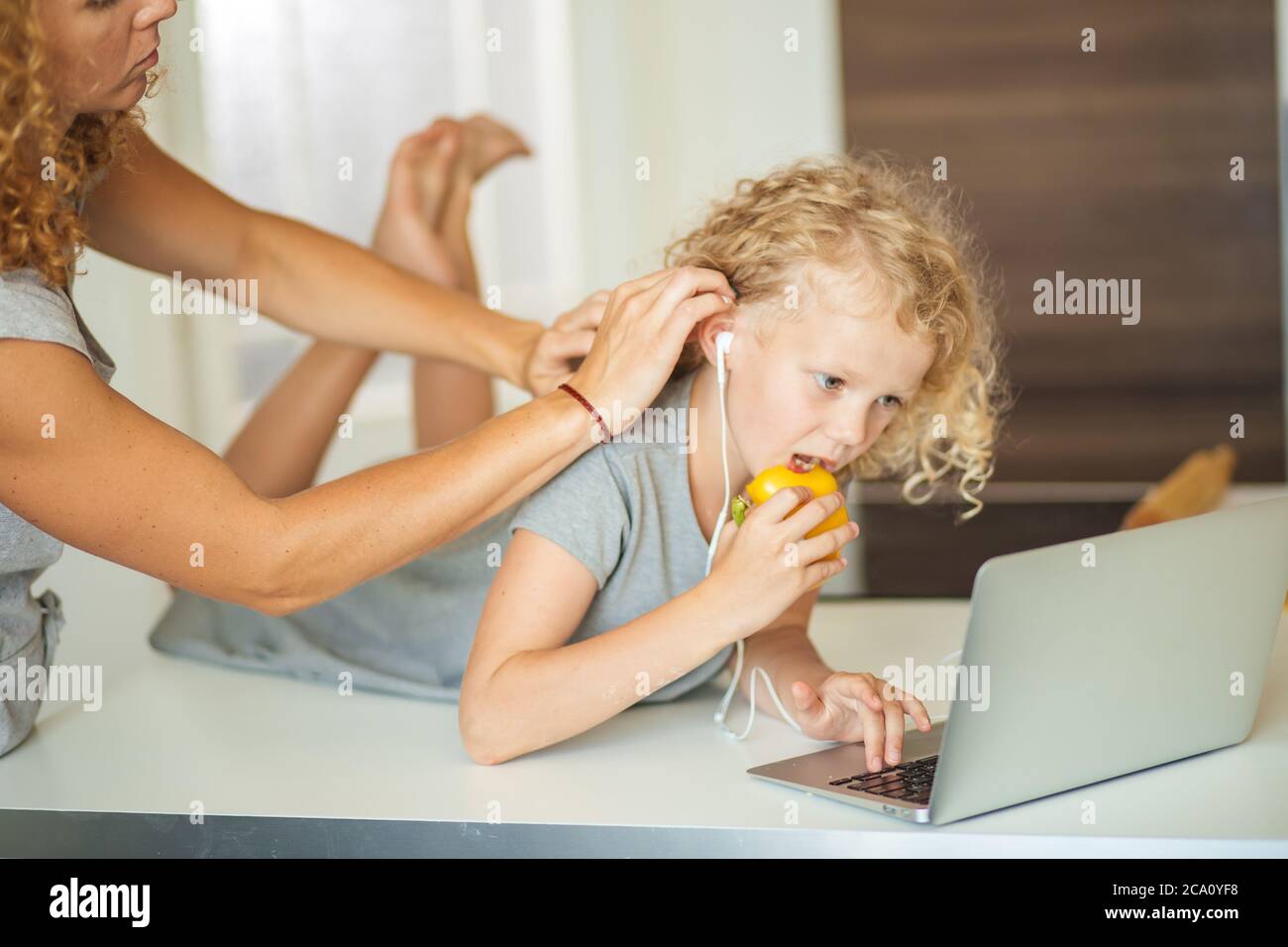 Everyday life in family with kids. Frizzy haired girl eating paprica ...