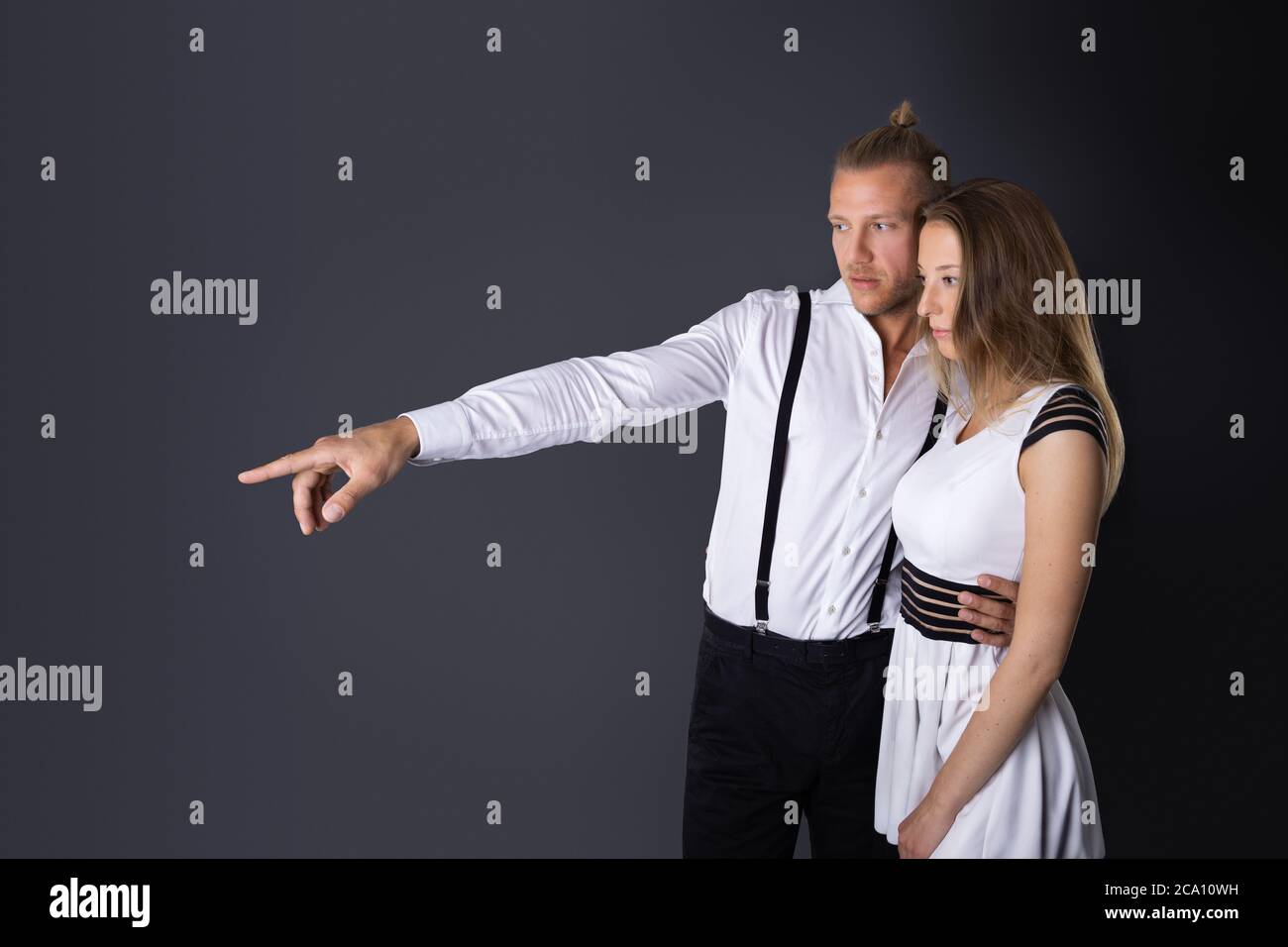 couple stand an look to side while man point on something Stock Photo ...