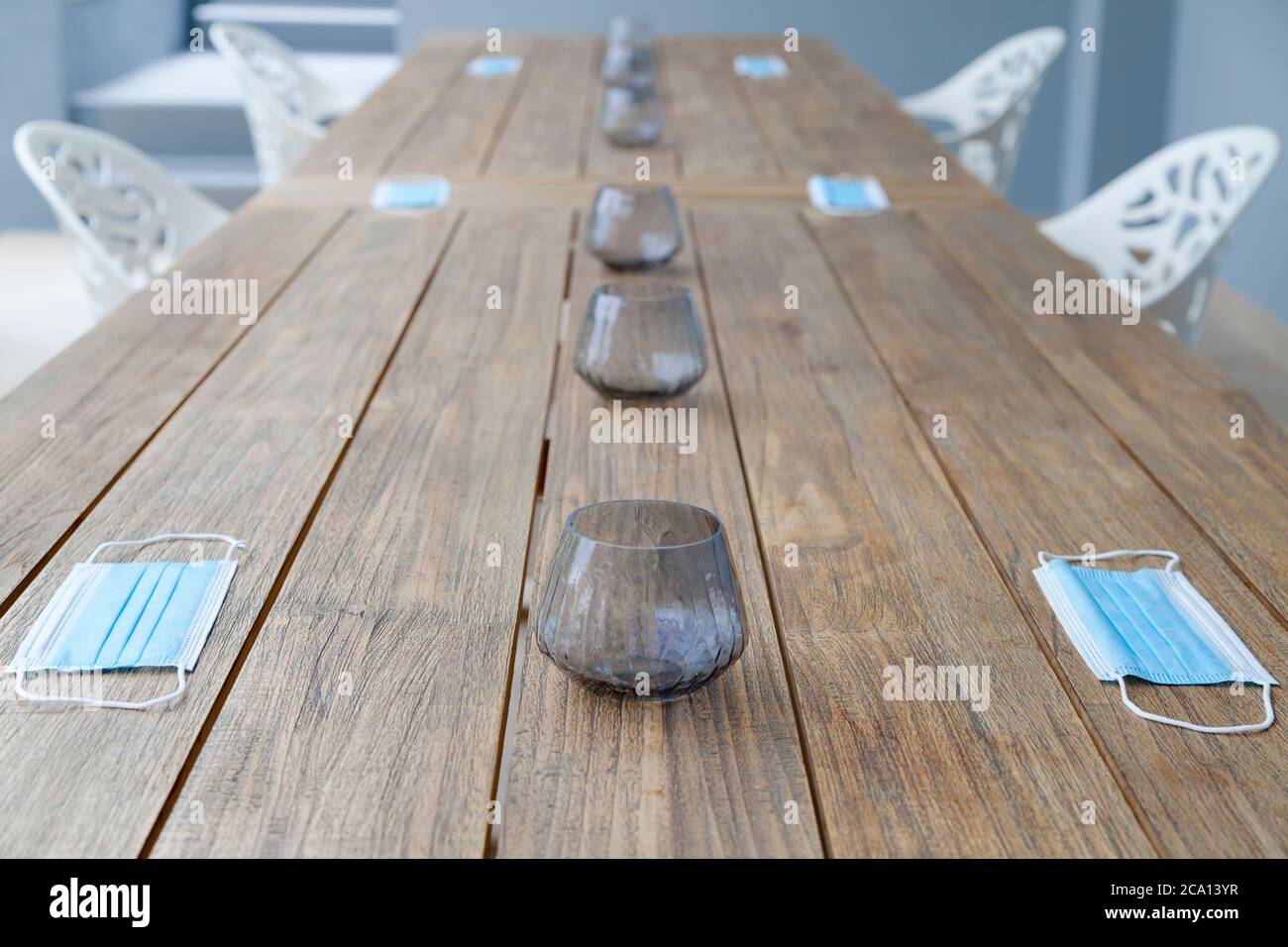 Face masks lying on a table with gaps between the chairs for social ...