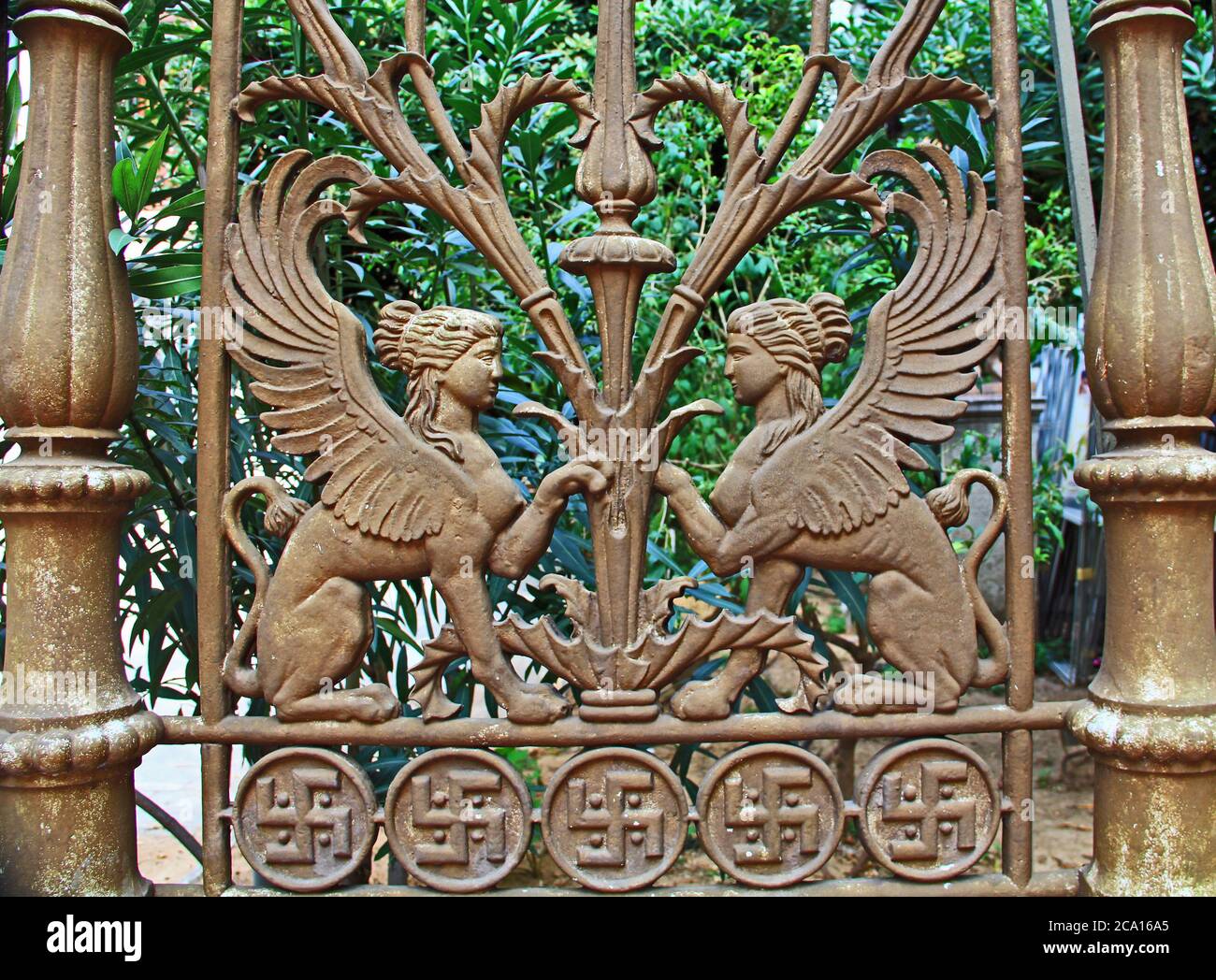 Decorative metal fence with two mythical sphinxes facing each other and ...