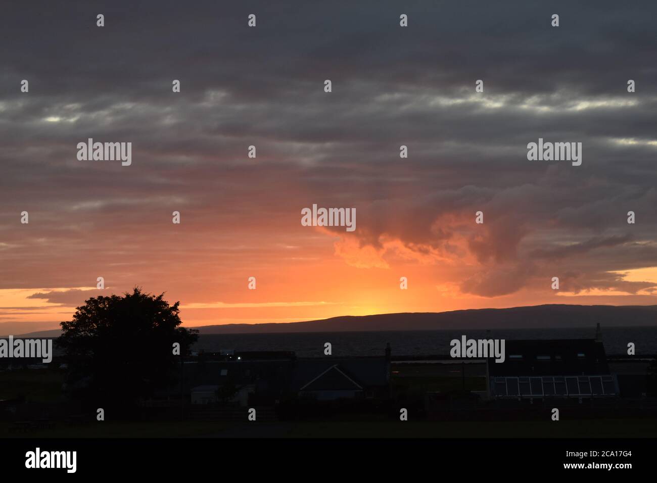 The face in the clouds appears to be blowing the sun over the horizon ...