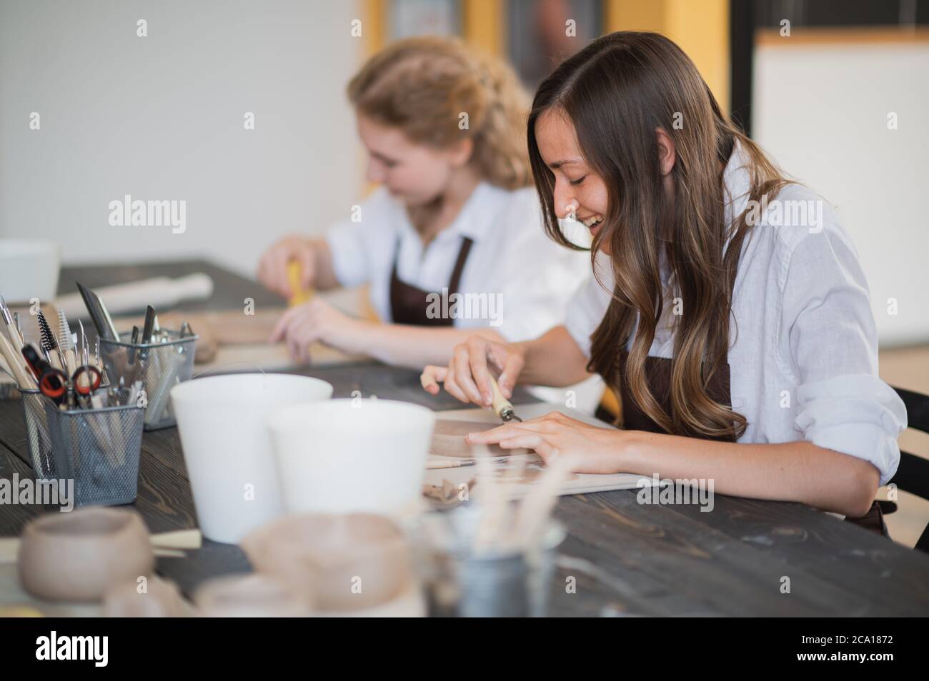 Beautiful young female artist girls creating handmade pottery in modern ...